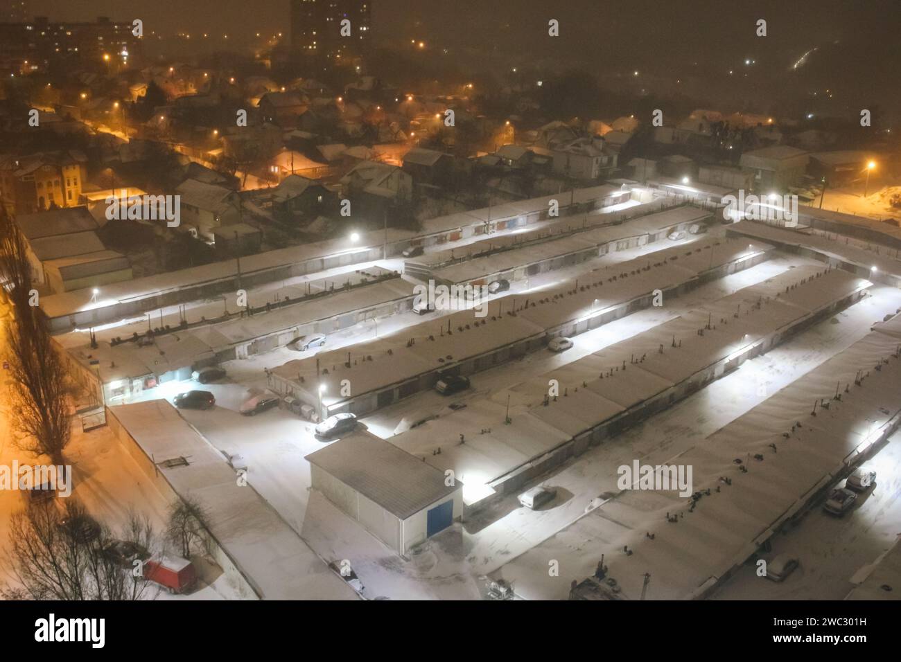 Garages under snow at night. Snowy cityscape. Cold weather in downtown ...