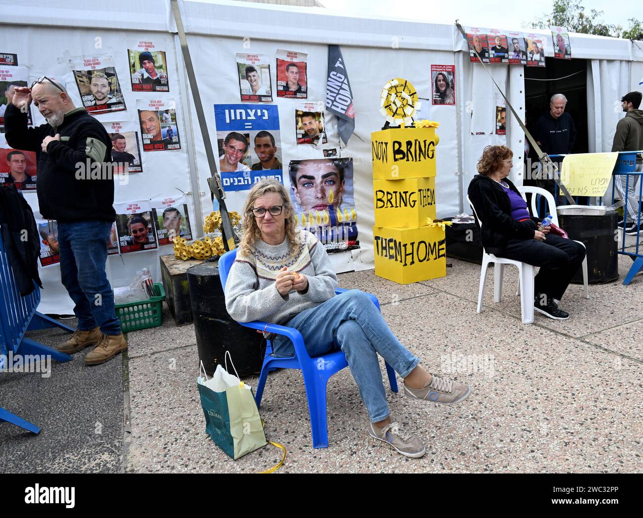 Tel Aviv, Israel. 13th Jan, 2024. People look at photos of Israelis ...
