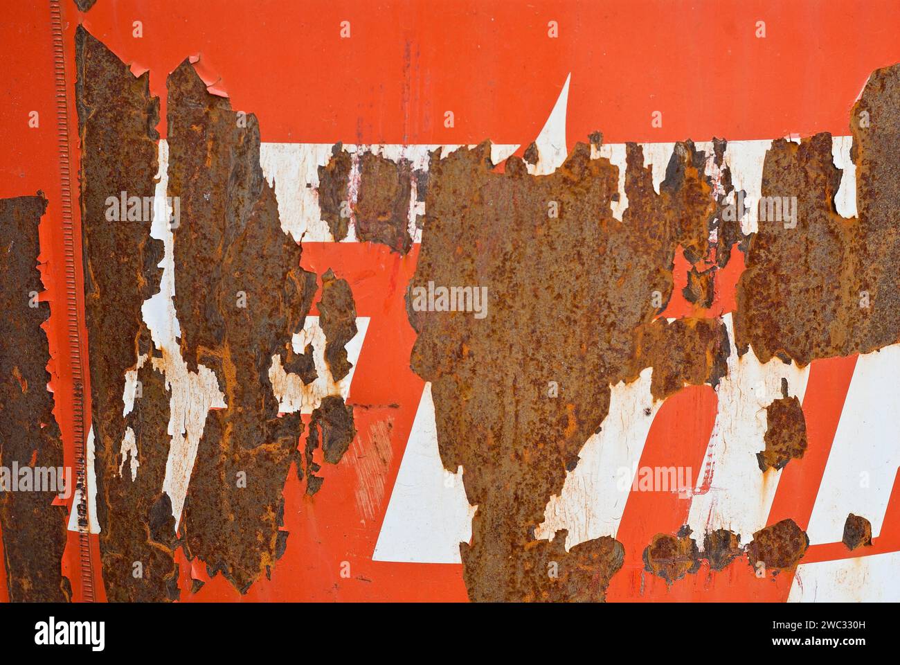 Rusty surface with peeling red paint and white stripes, weathering ...