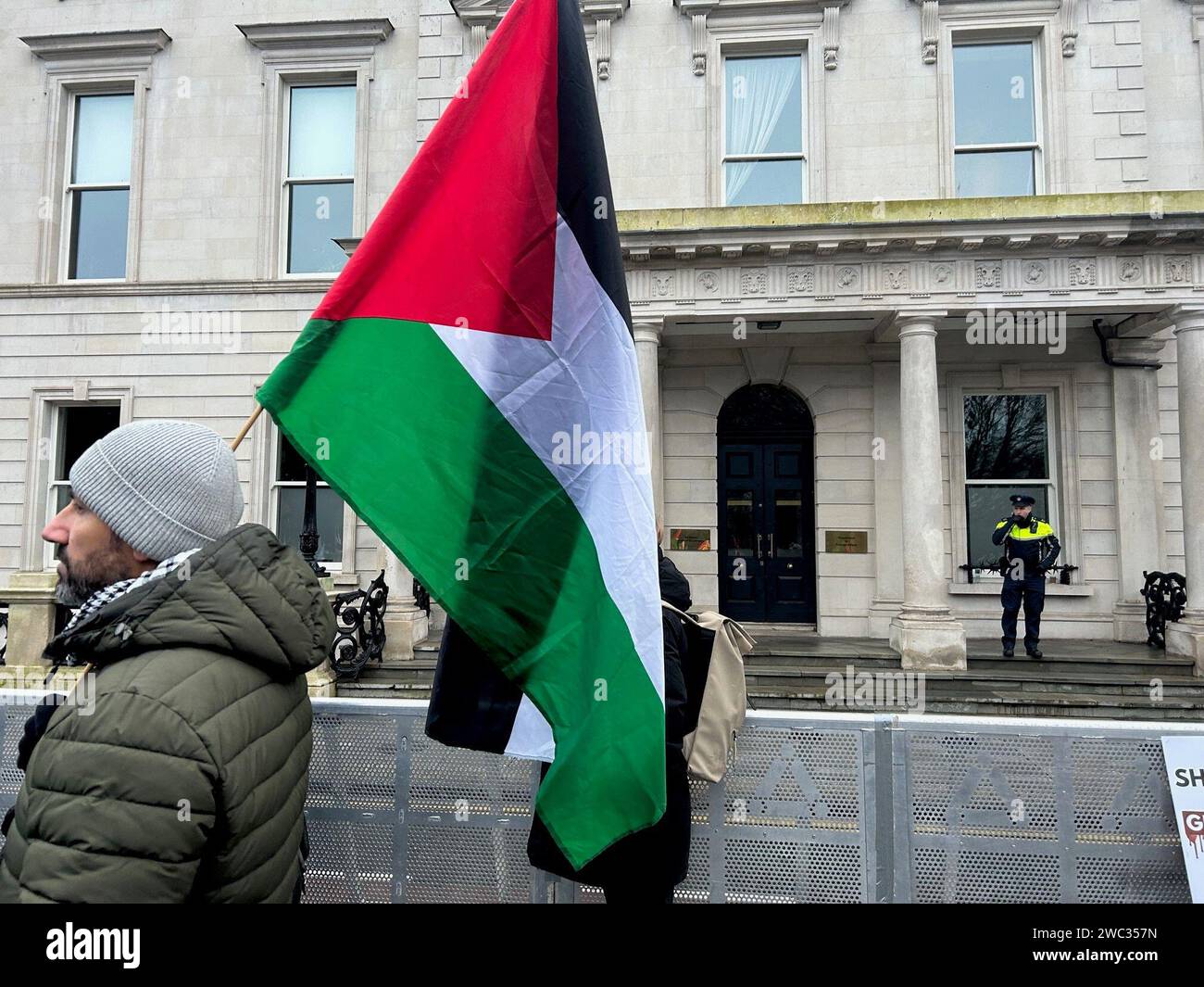 Man with Palestinian flag walking past barricaded Department of Foreign ...