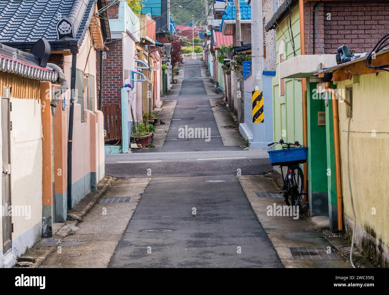 Small paved roadway extending into the distance with old buildings on ...