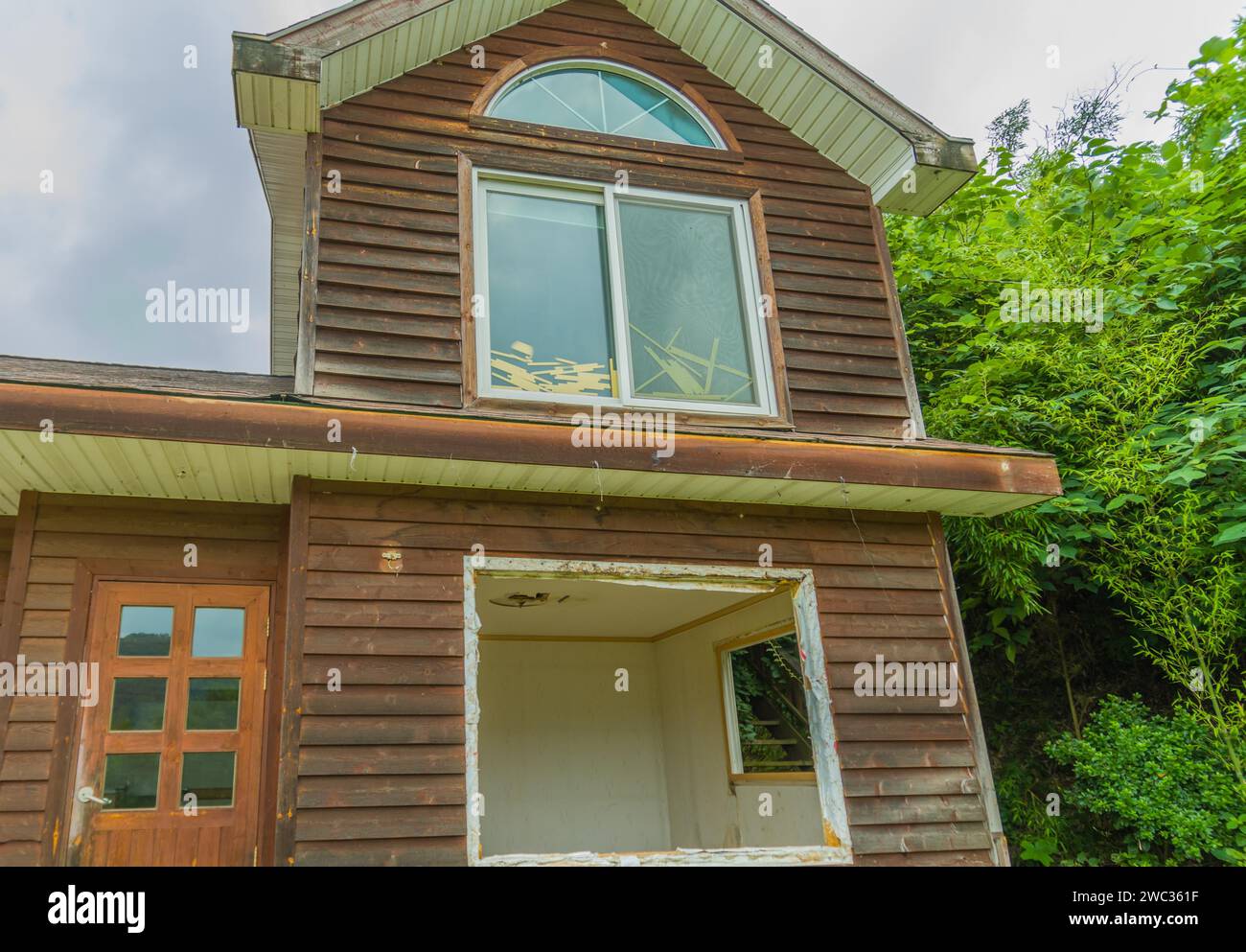 View of window on second story, front door and first floor window frame ...