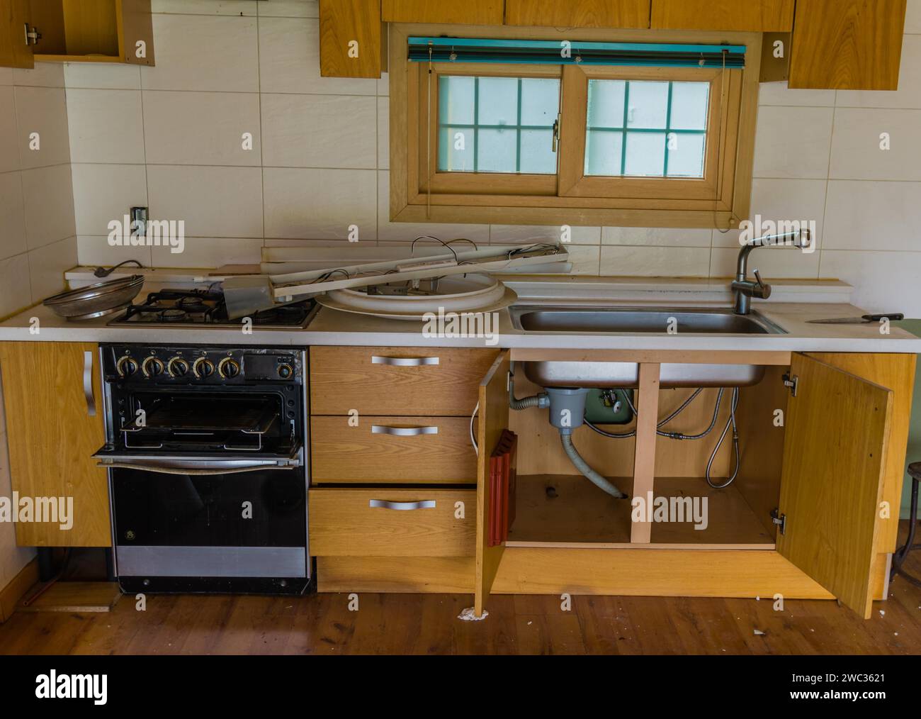 Kitchen cabinets of abandoned house with electrical fixtures debris on ...