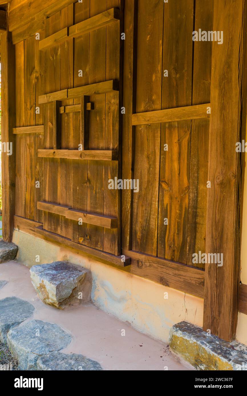 Oriental wooden door that slides to open and close on old stucco ...