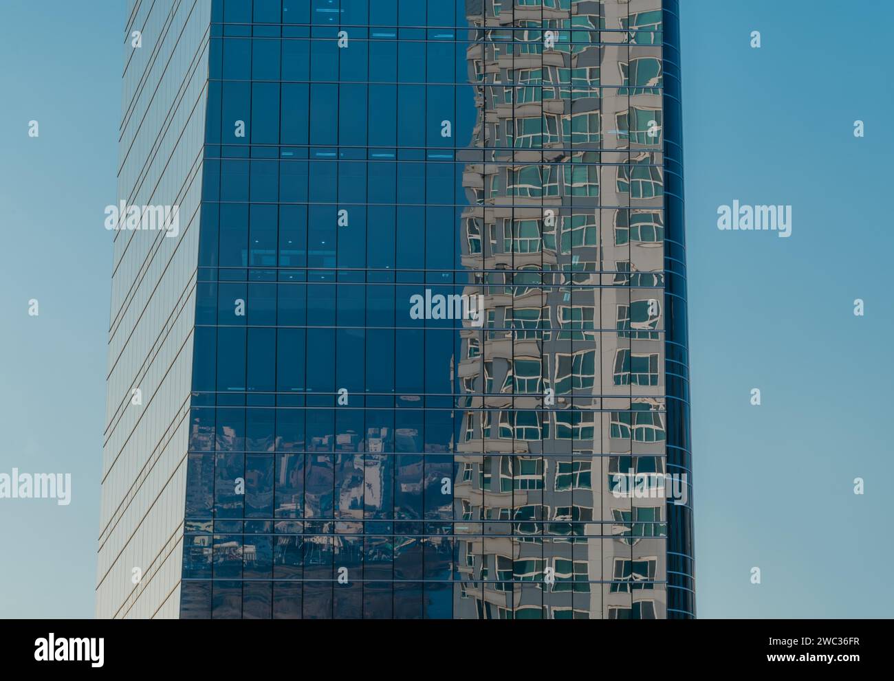 Low angle view of glass office building with reflection of brick ...