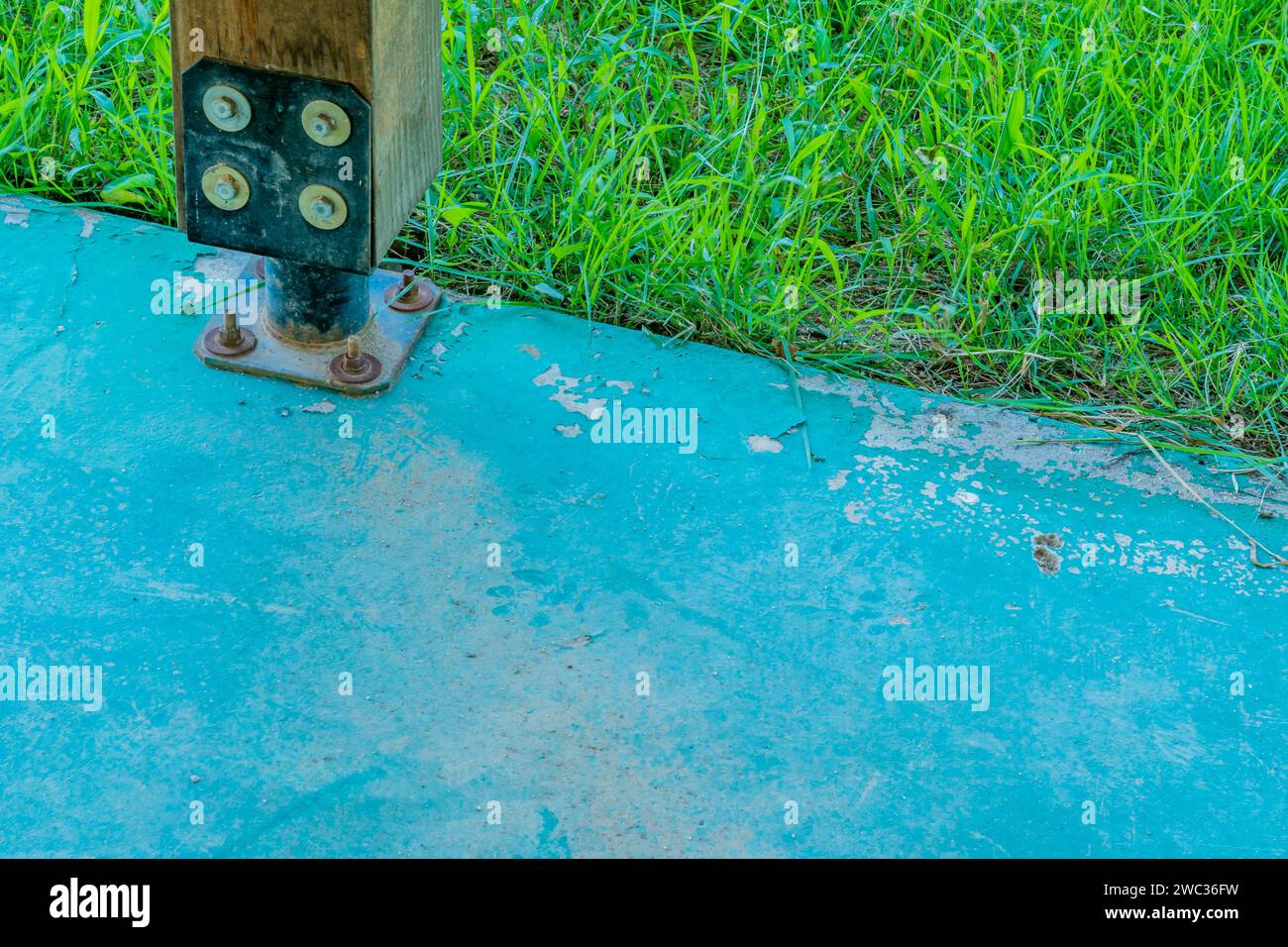 Square wooden support column attached to concrete base using metal ...