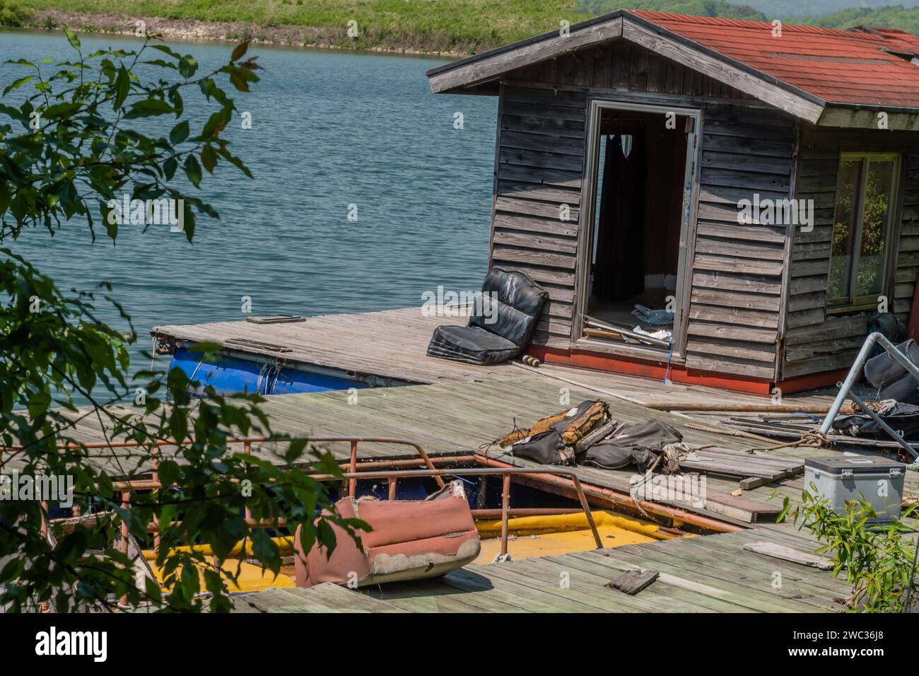 Old abandoned fishing shack and dock cluttered with trash and debris ...