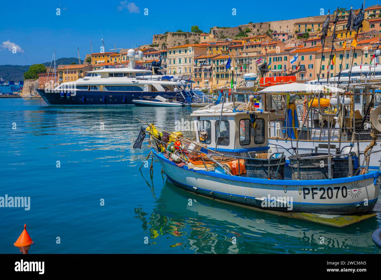 Fishing boats and luxury yachts in the harbour of Portoferraio, Elba ...