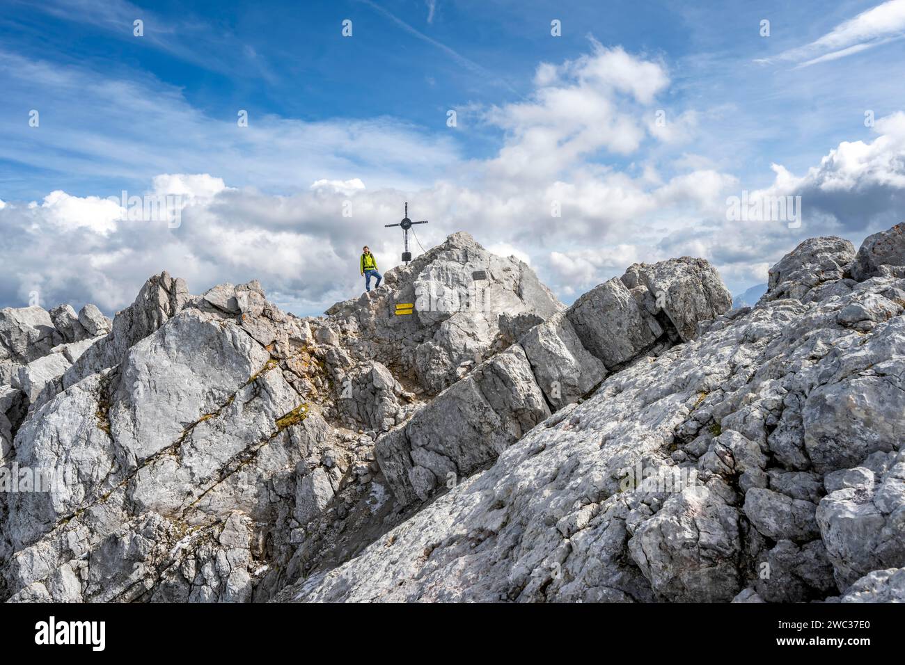 Mountaineer on the rocky summit of the Watzmann Mittelspitze with ...