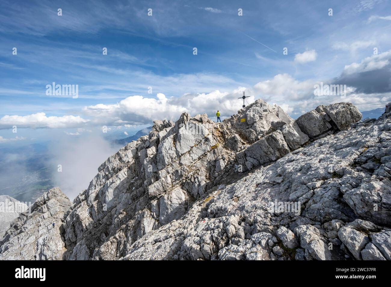 Mountaineer on the rocky summit of the Watzmann Mittelspitze with ...