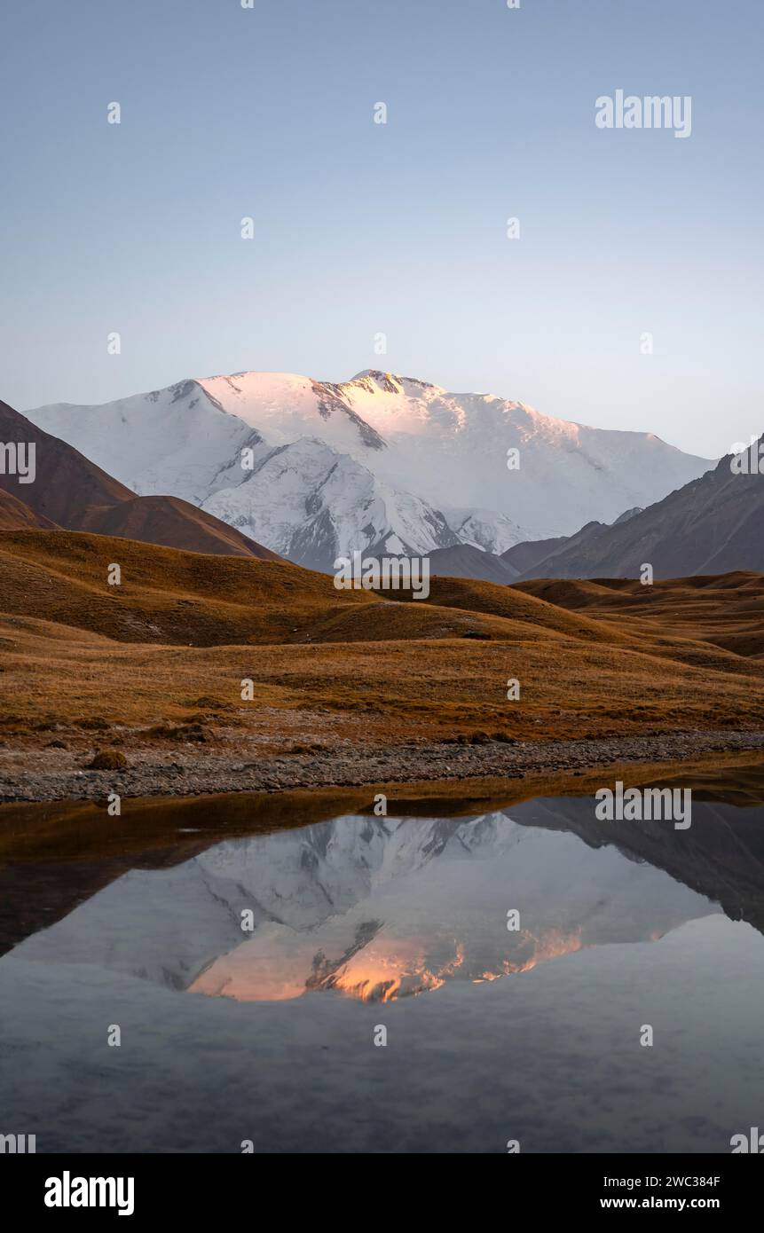 White glaciated and snowy mountain peak Pik Lenin at sunset, mountains ...