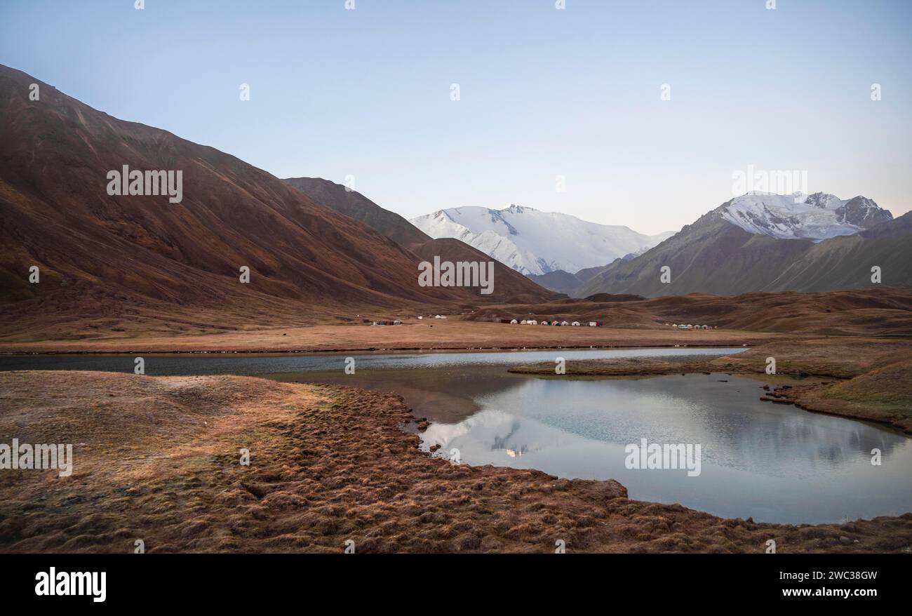 Yurts, mountains reflected in a small mountain lake, Pik Lenin, Trans ...