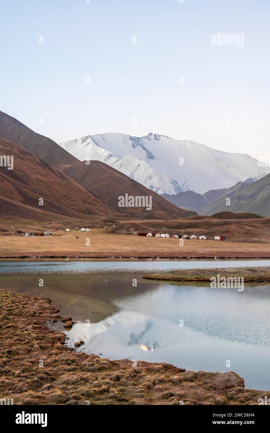 Yurts, mountains reflected in a small mountain lake, Pik Lenin, Trans ...