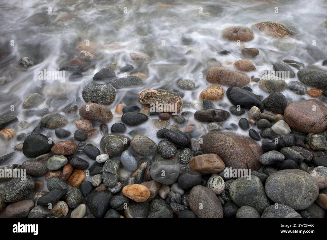 Stones on the beach with running water, Sommaroy, Norway Stock Photo ...