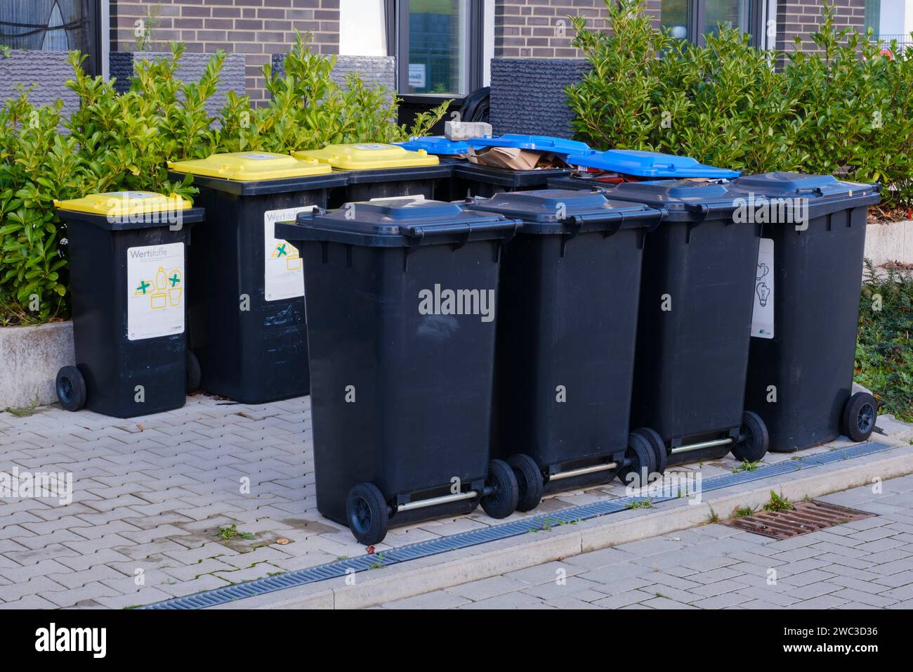 Waste bins for recyclables, paper and residual waste in front of a ...