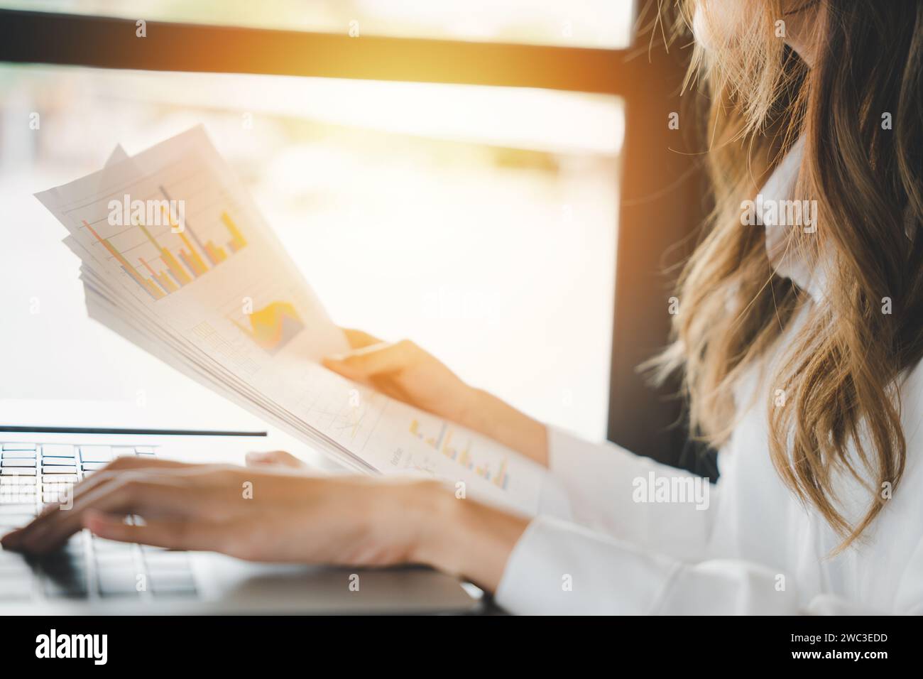 Businesswoman working and comparing forecasting and graphic documents ...