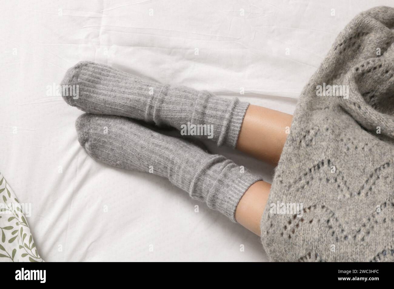 Pair of female legs wearing cozy grey cashmere socks under blanket in ...