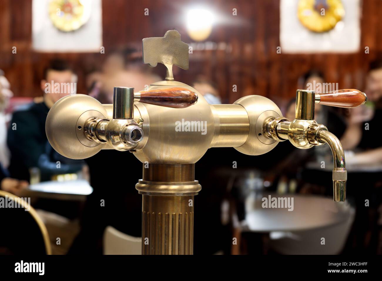 Beer tap with pub guests in the background Stock Photo - Alamy