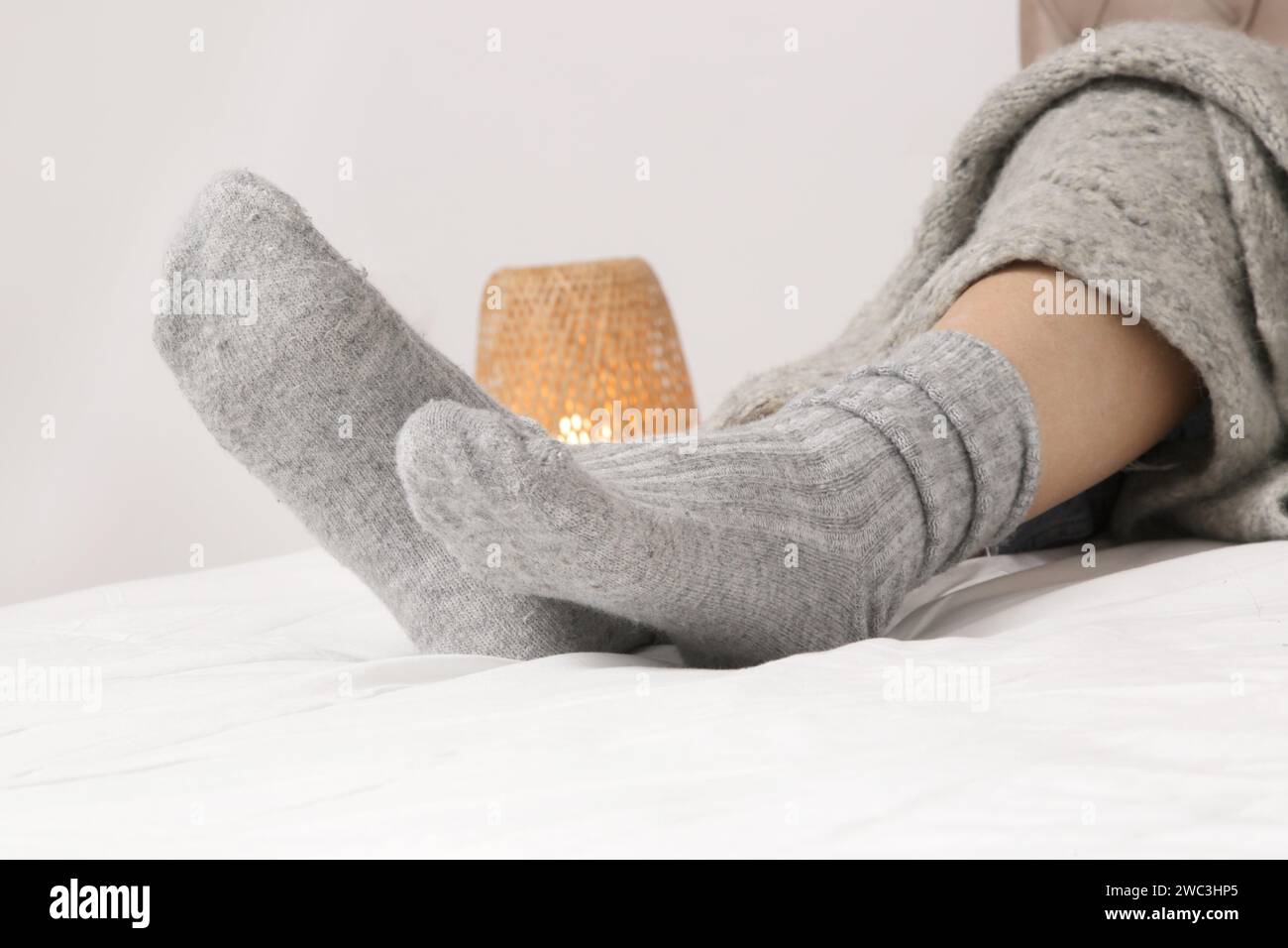 Pair of female legs wearing cozy grey cashmere socks under blanket in ...