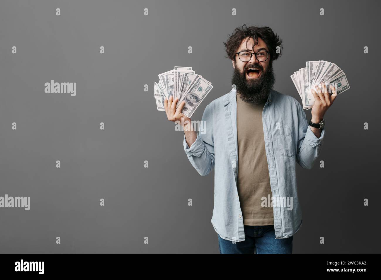 Joyful Man Showing Off Multiple Dollar Bill Fans Stock Photo - Alamy
