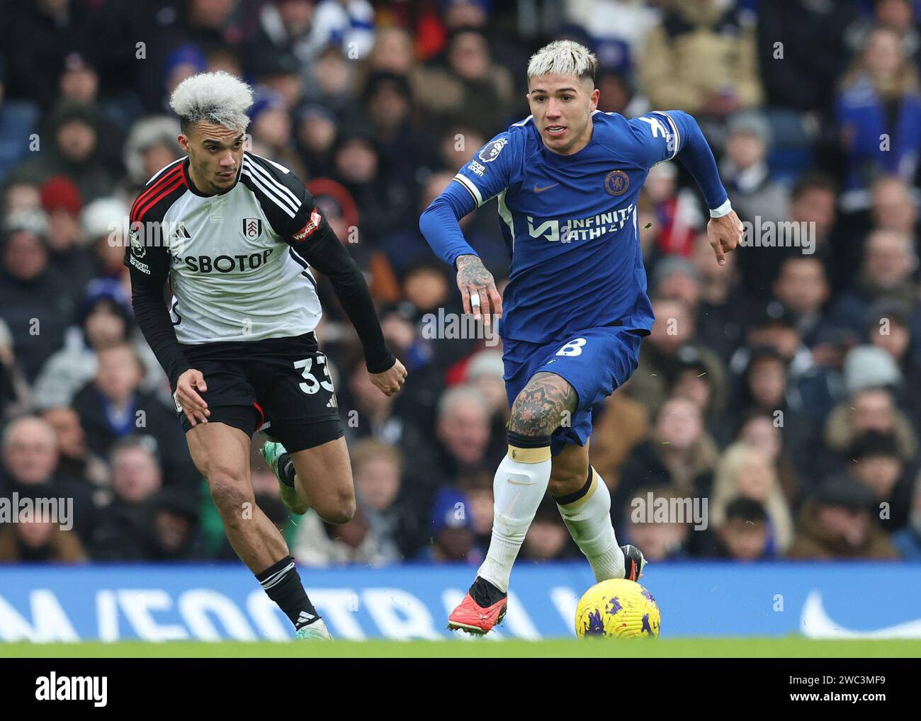 London, UK. 13th Jan, 2024. Antonee Robinson of Fulham and Enzo Fernández of Chelsea challenge ...