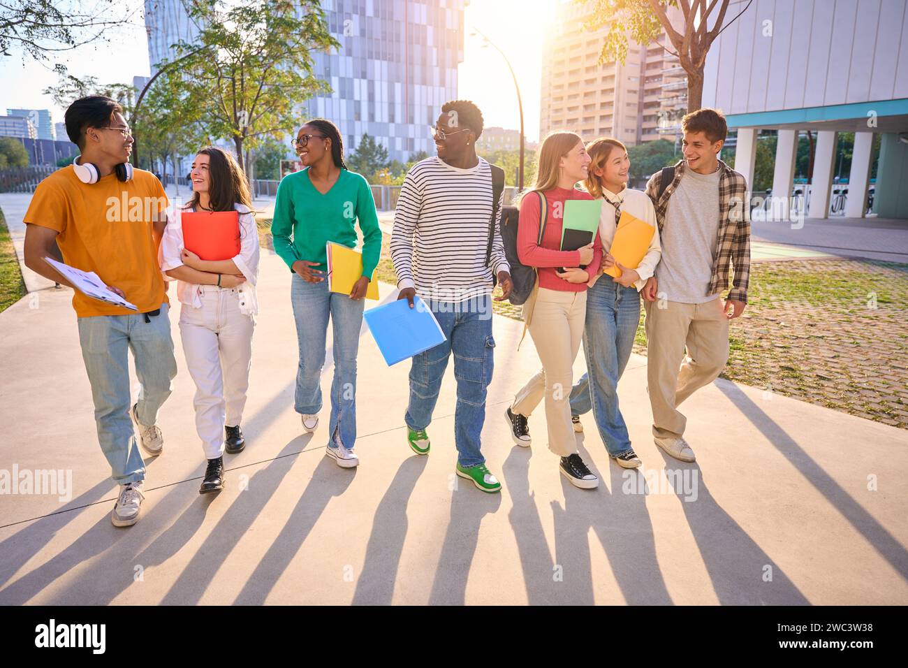Happy international students walking around the university campus ...