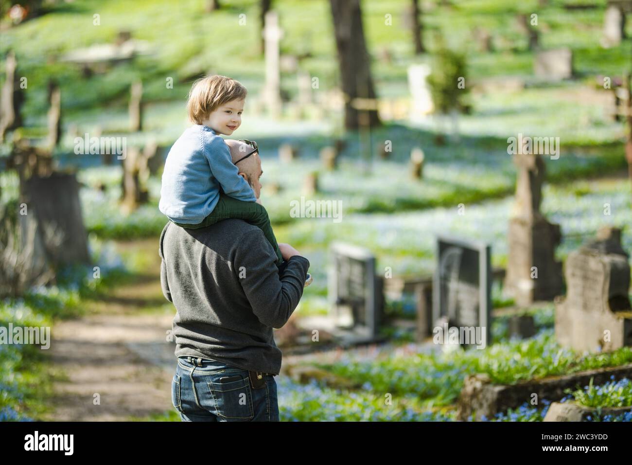 Cute toddler boy and his father admiring blue scilla siberica spring ...