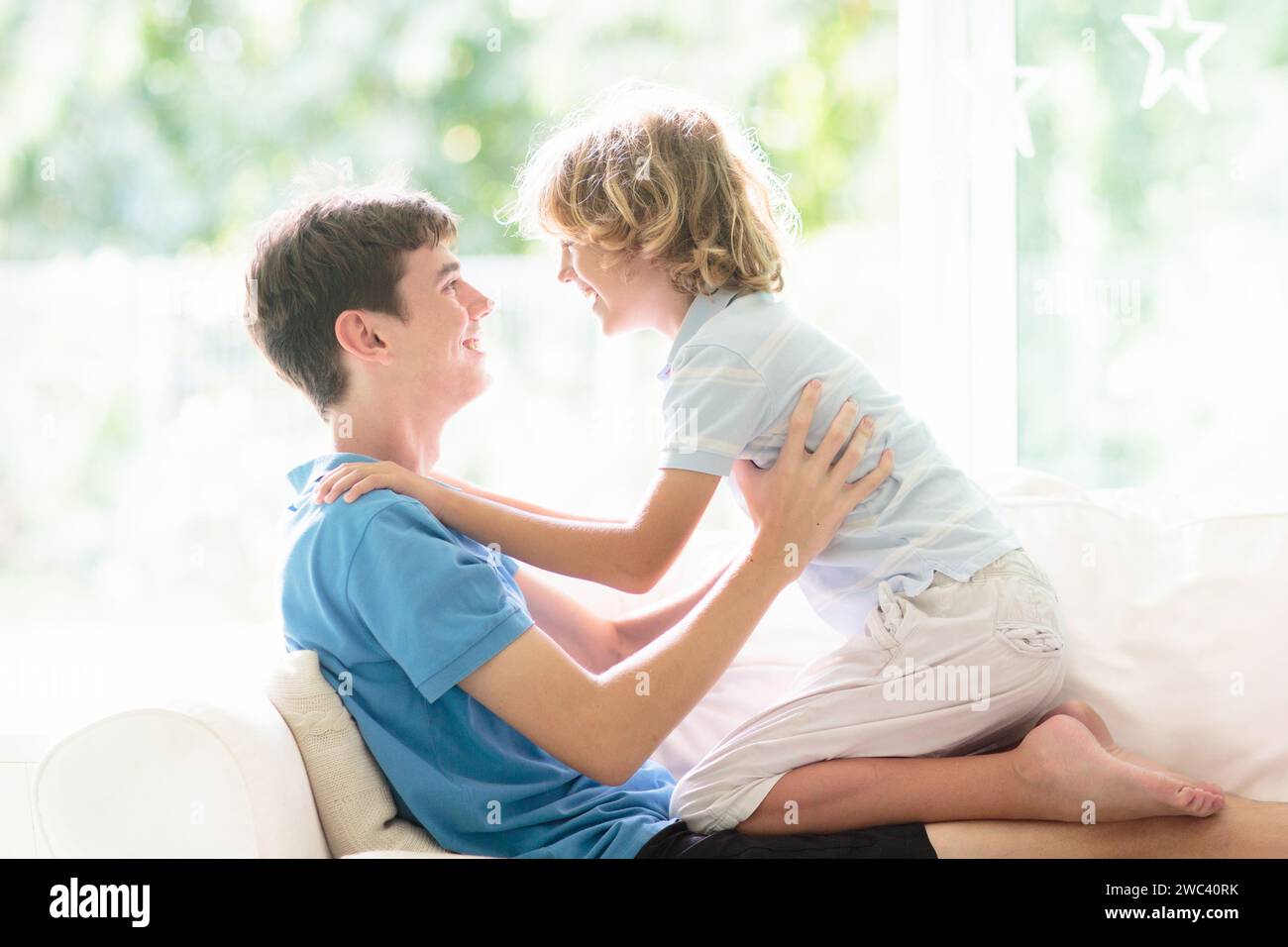 Man and little boy at home on sunny summer day. Brothers with large age ...