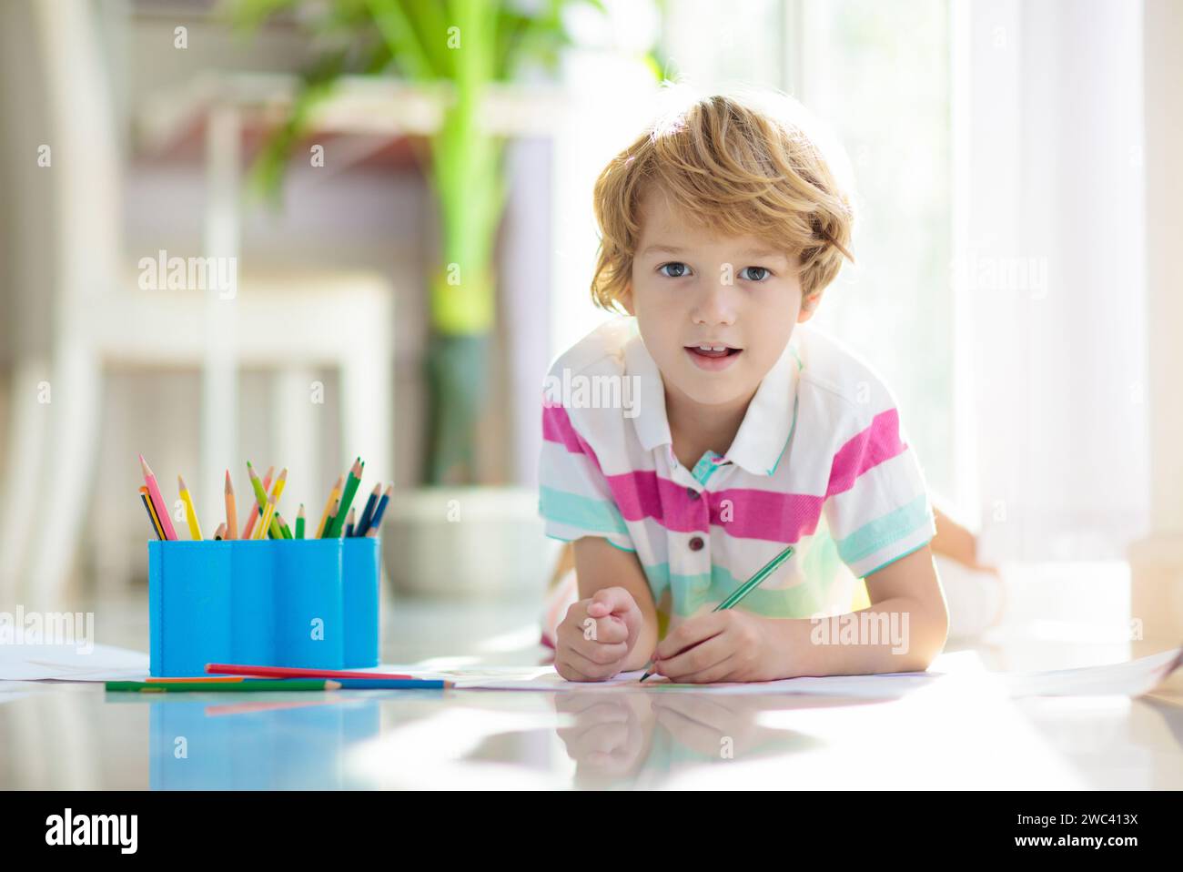 Child drawing lying on the floor. Kid painting rainbow. Online remote ...