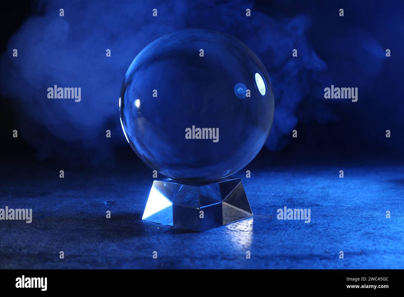 Magic crystal ball on table against dark background. Making predictions ...