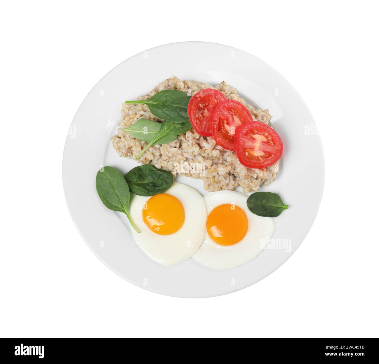 Delicious boiled oatmeal with fried eggs, tomato and basil isolated on ...