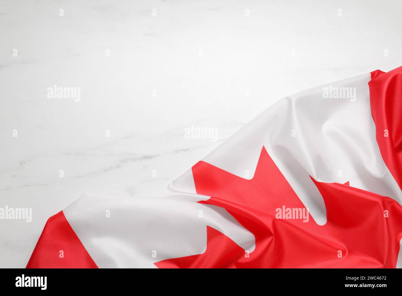 Flag of Canada on white marble background, top view. Space for text ...