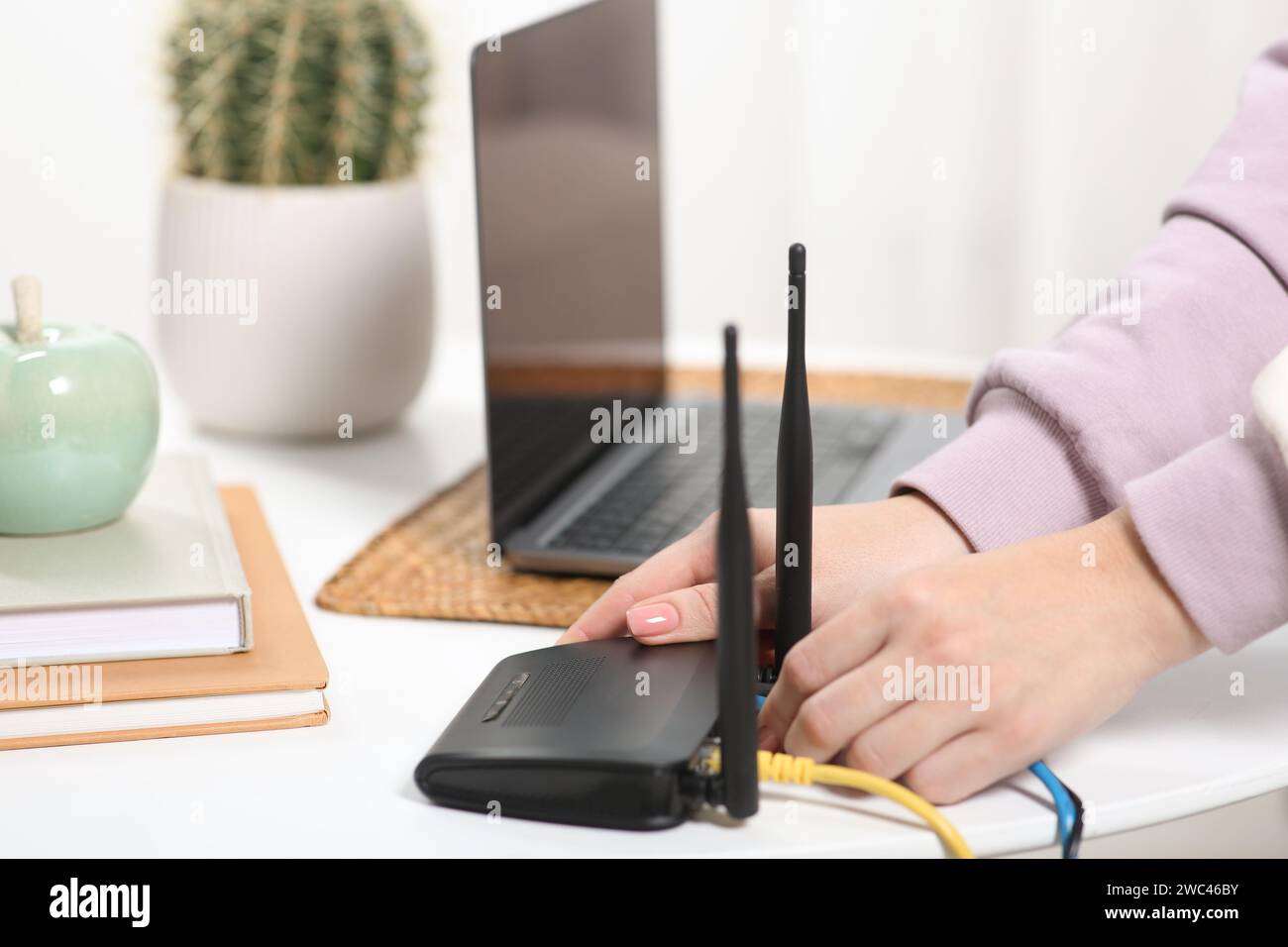 Woman connecting cable to Wi-Fi router at table indoors, closeup Stock ...