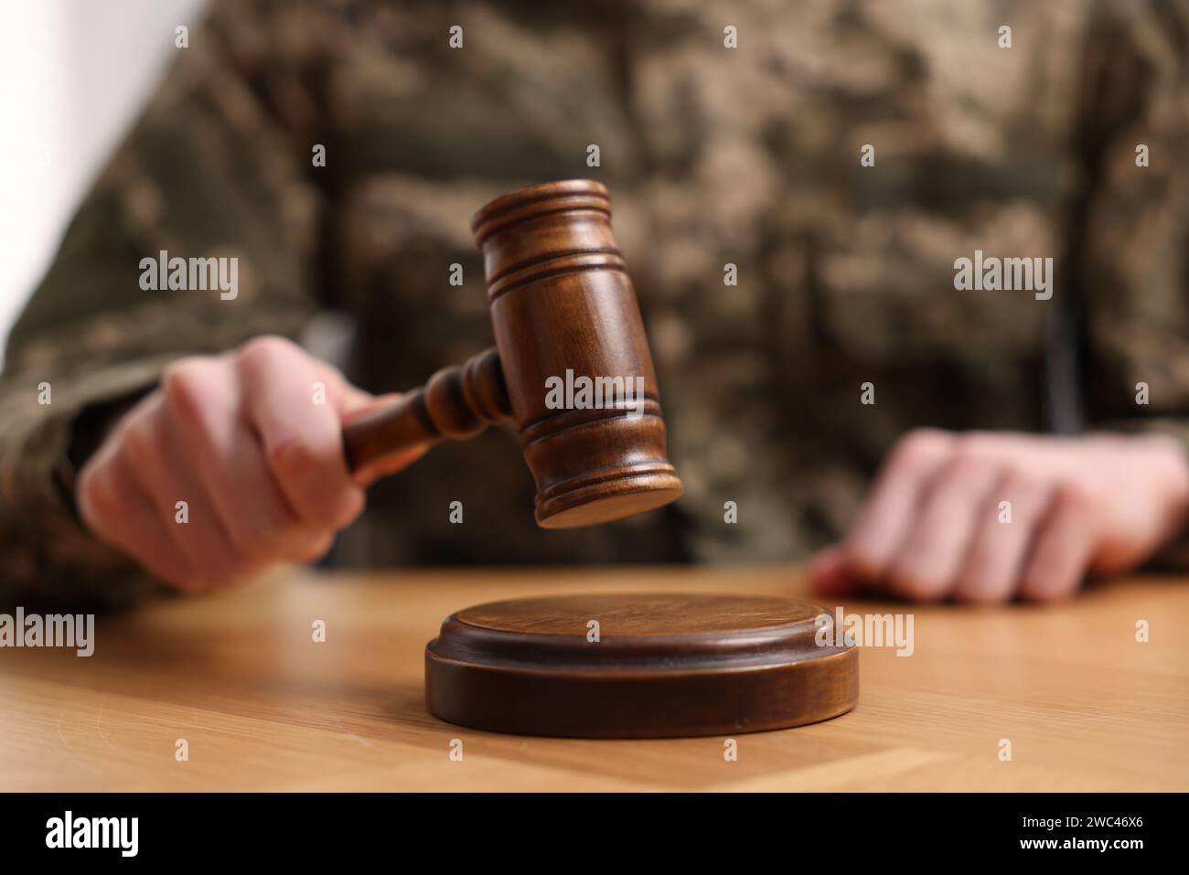 Law concept. Man in military uniform with gavel at wooden table ...