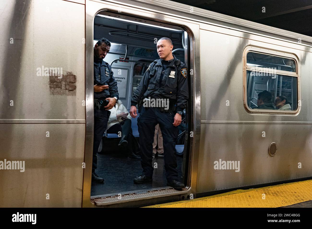 NYPD officers stand aboard a train at the West Fourth Street subway ...