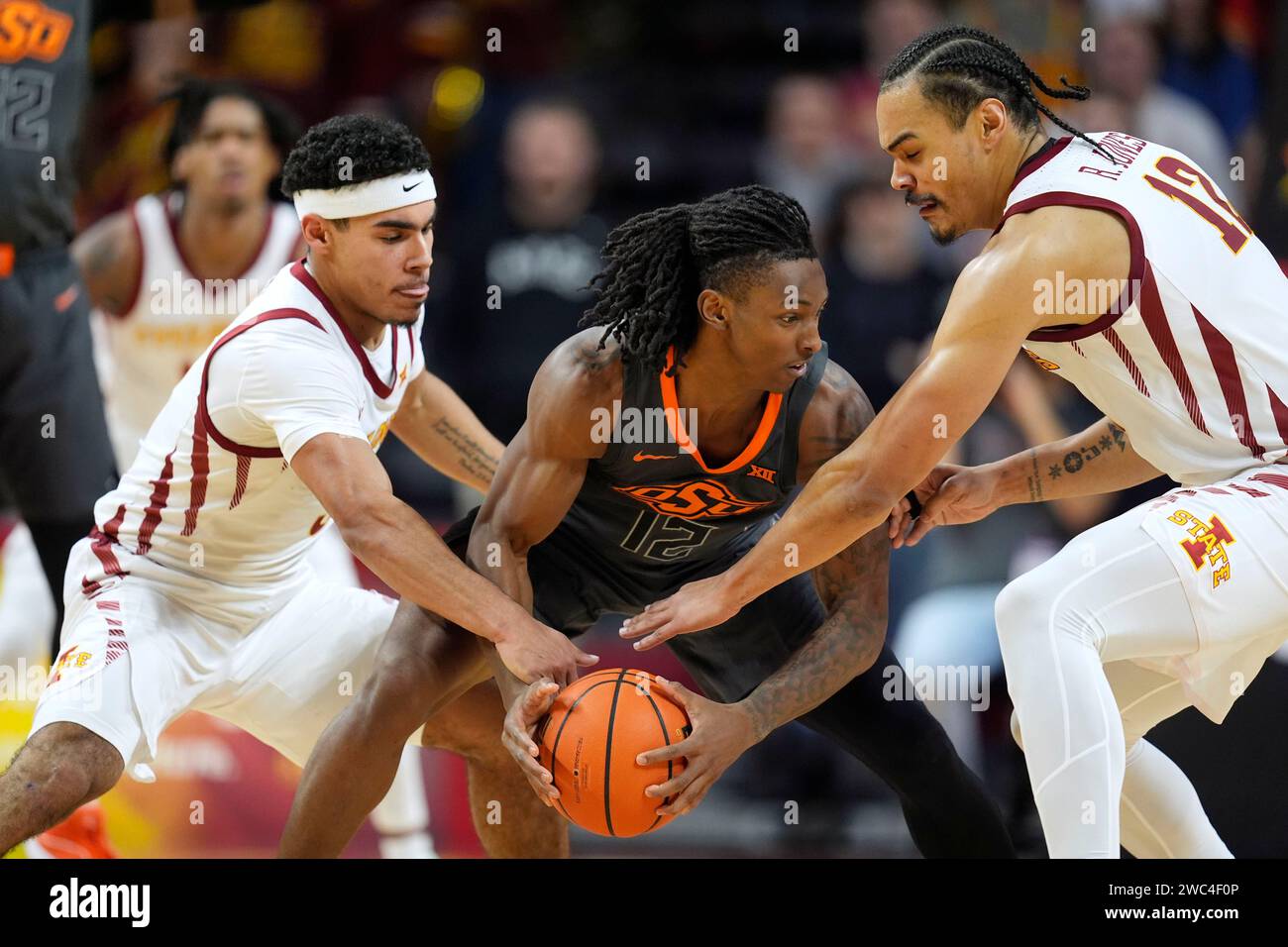 Iowa State guard Tamin Lipsey, left, and forward Robert Jones, right, try to steal the ball from ...