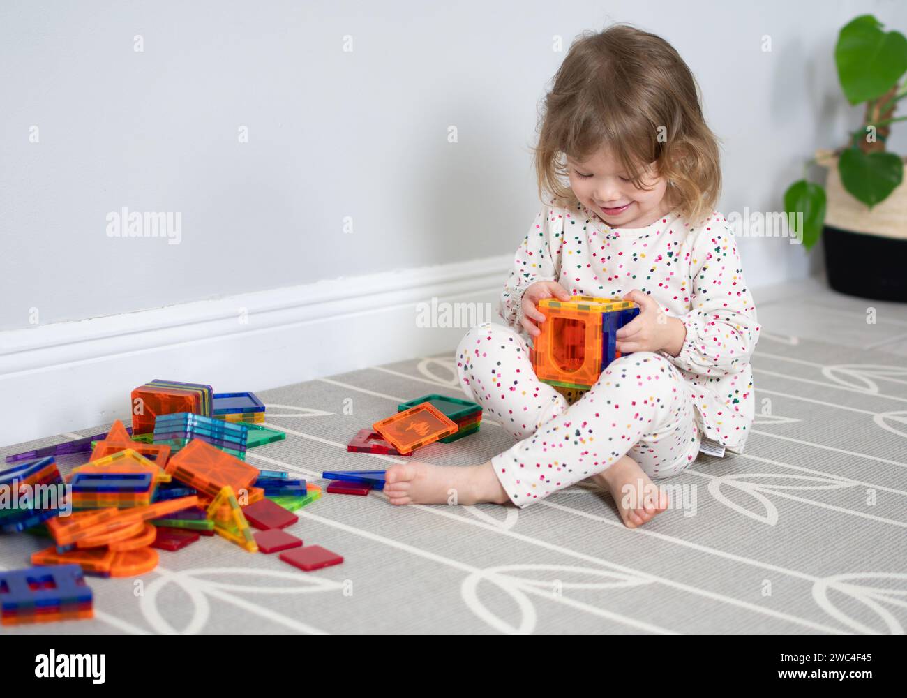 Little Caucasian Toddler girl playing with magnetic tiles. Magna tiles ...