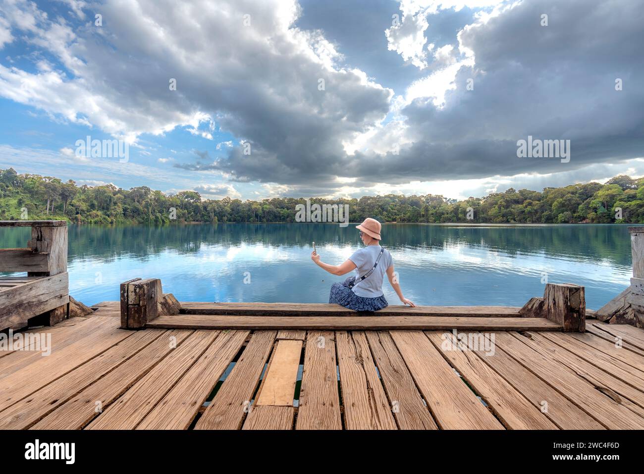 Lake Yeak Laom, Krong Ban Lung, Cambodia-December 29, 2023: Female tourist takes a selfie by ...