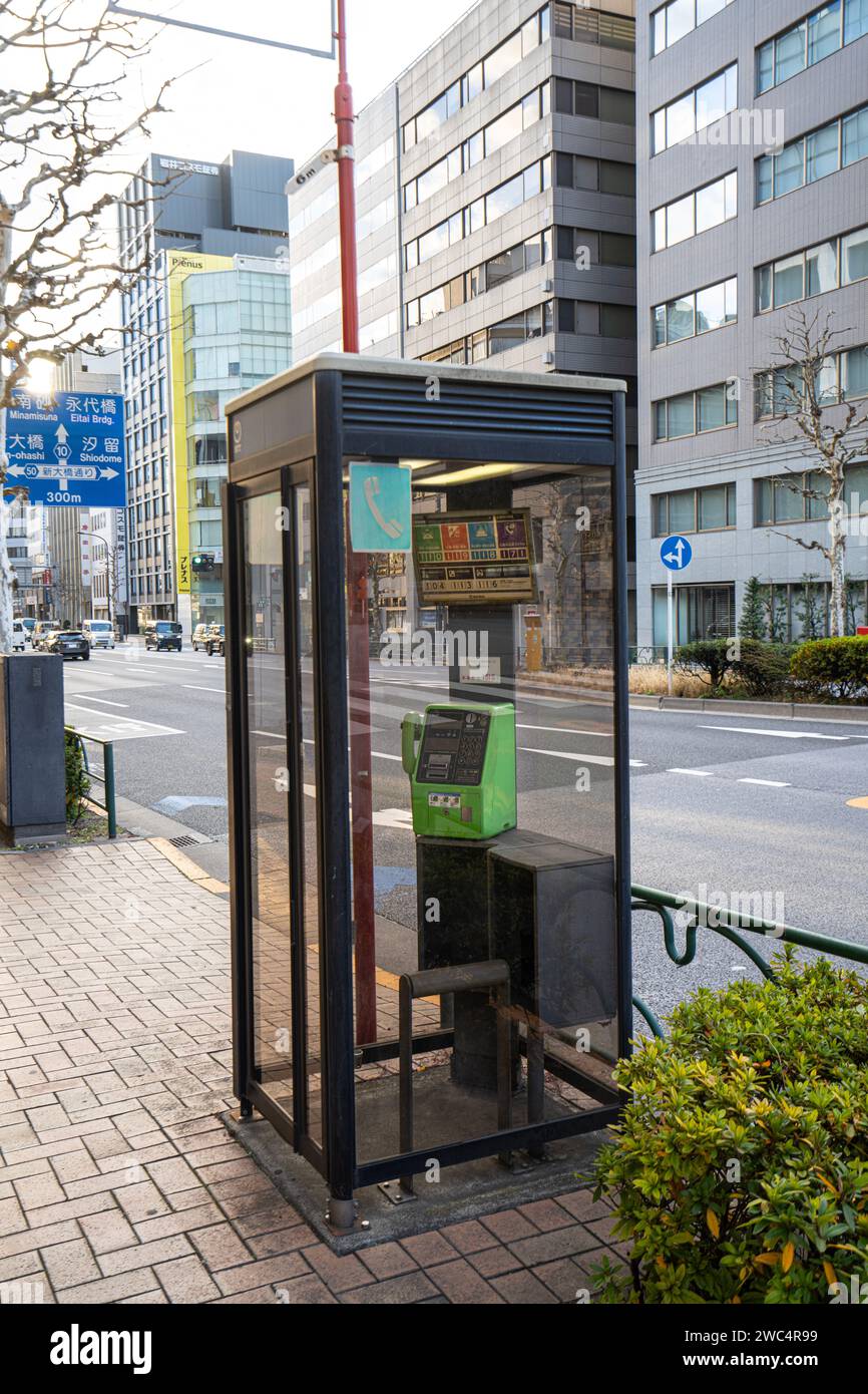 Tokyo, Japan, January 2024. a public telephone booth on the pavement of ...
