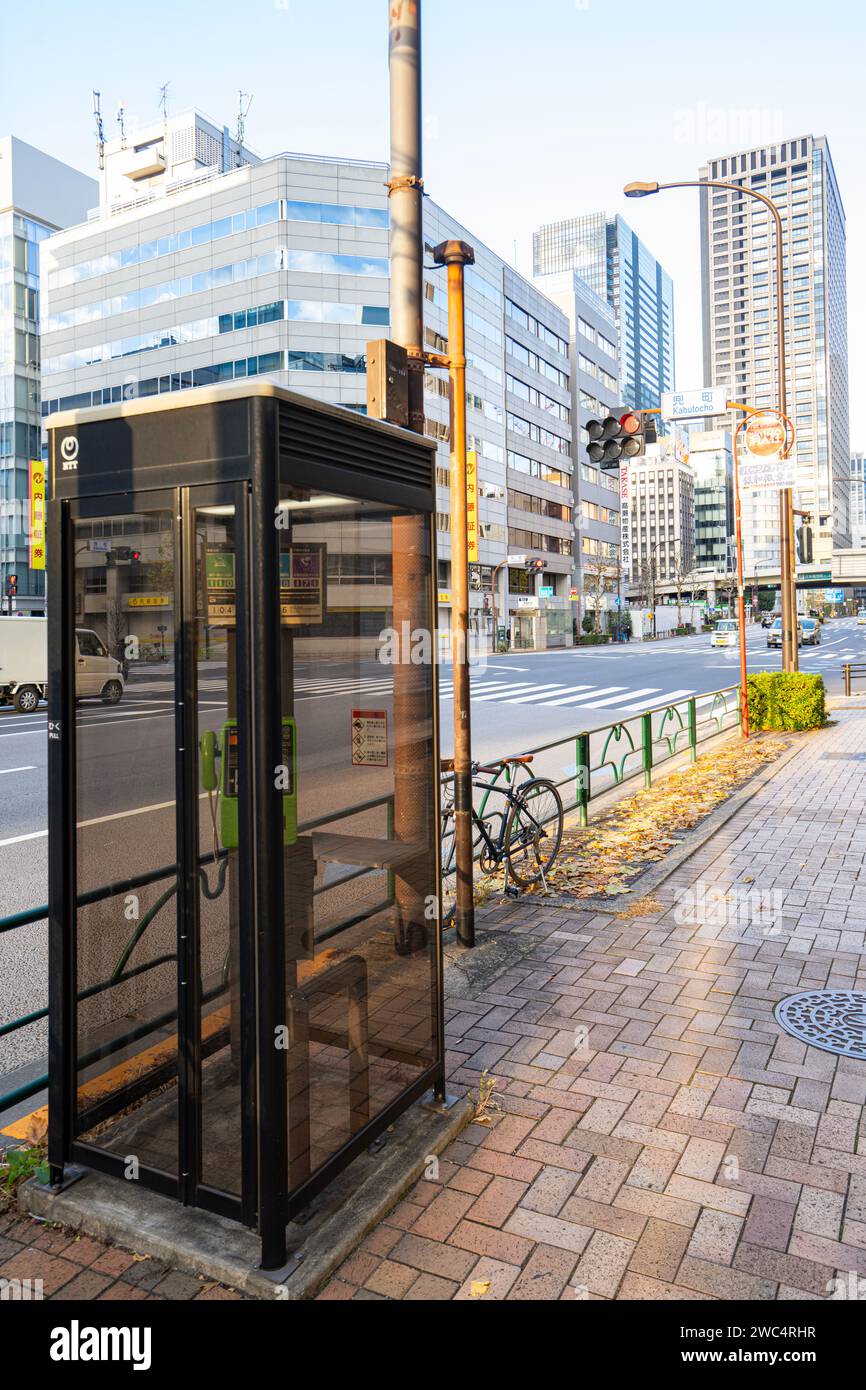 Tokyo, Japan, January 2024. a public telephone booth on the pavement of ...