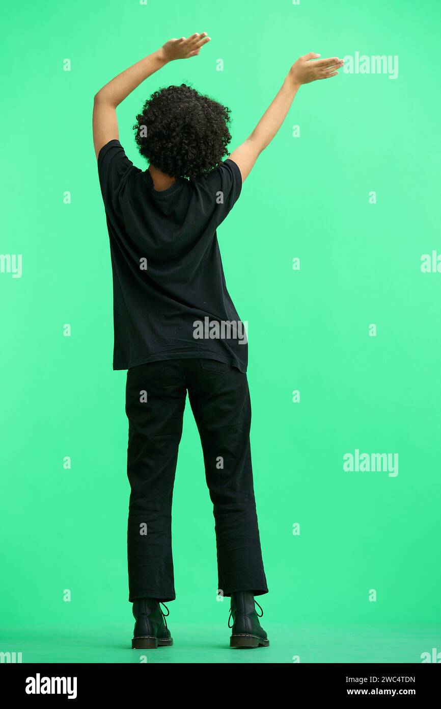 A woman, full-length, on a green background, waving her arms Stock ...
