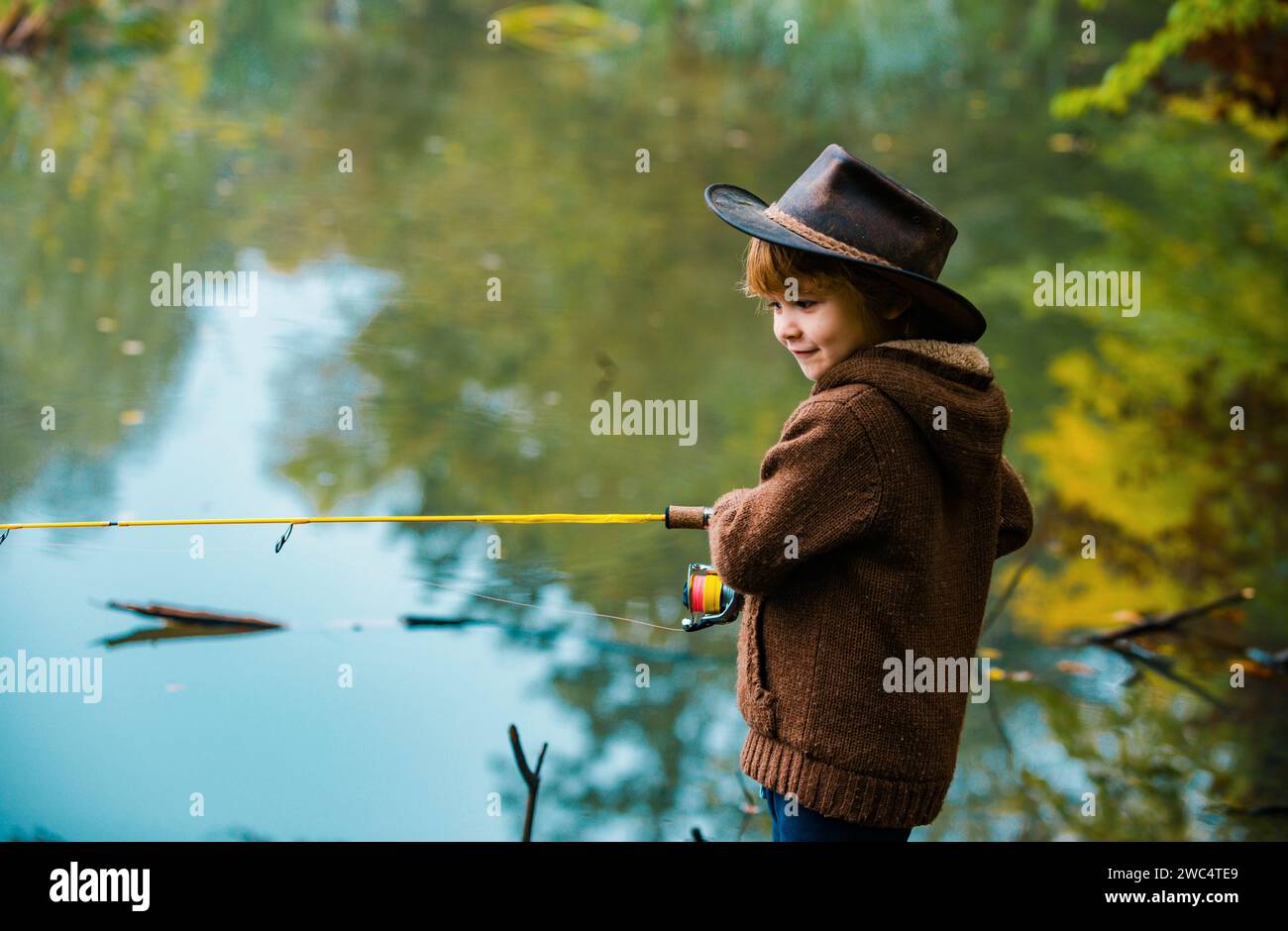Child learning how to fish, holding a rod on a lake. Kid with fishing ...