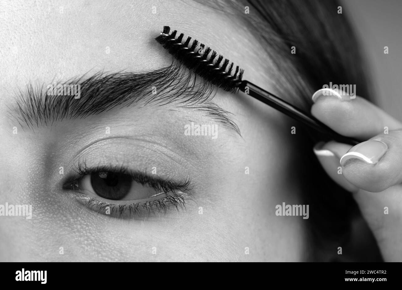 Eyebrow makeup. Woman brushing brows with brows brush closeup. Macro ...