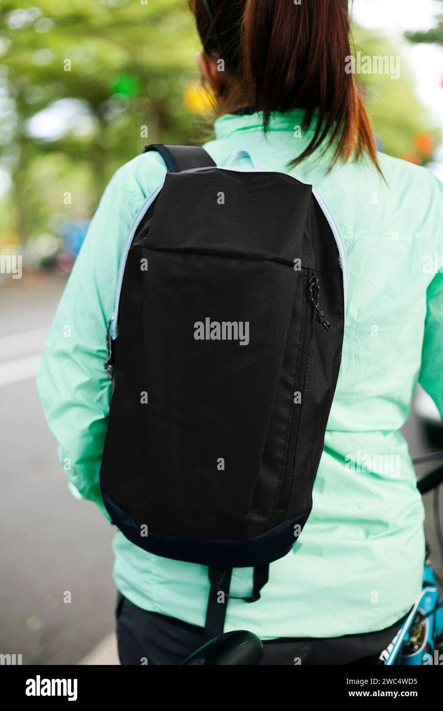 Rear view of female with black backpack Stock Photo - Alamy
