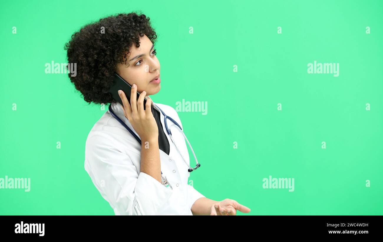 Female doctor, close-up, on a green background, with a phone Stock ...