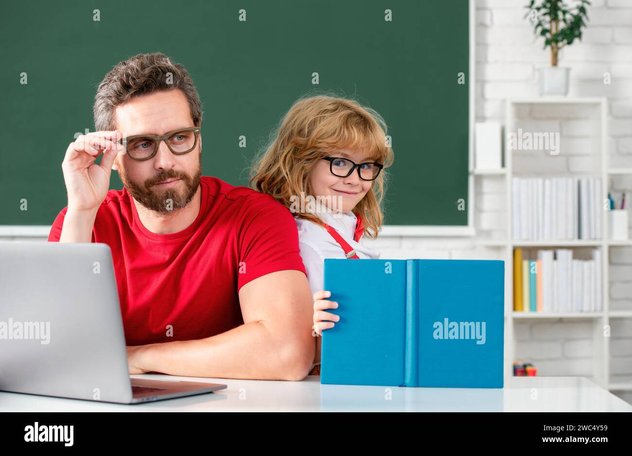 Teacher and pupil boy learning in the classroom. Teacher and little ...