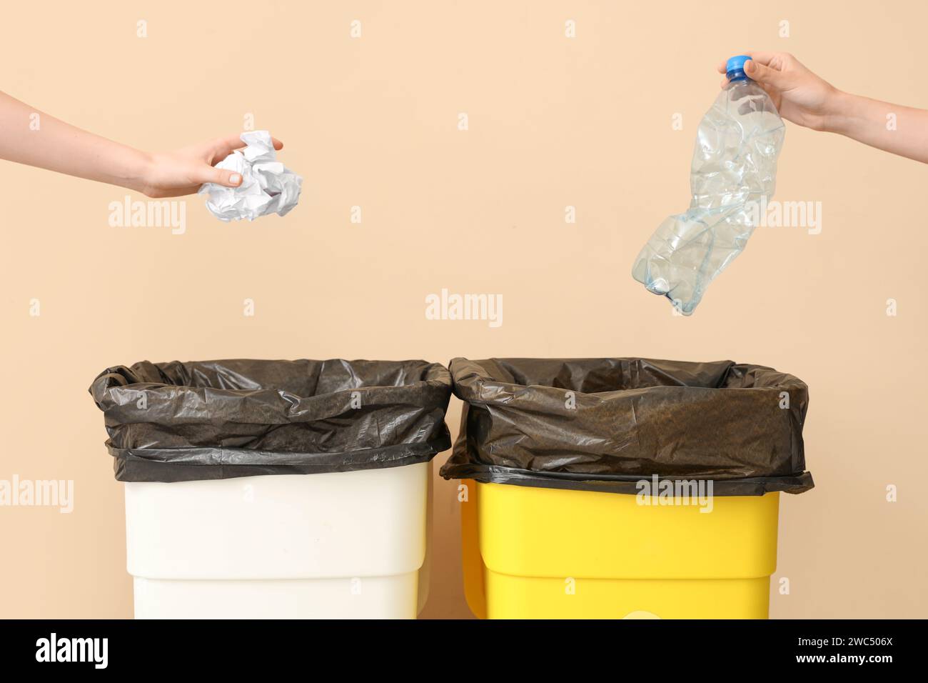 Female hands throwing garbage into trash bins with recycle logo near ...