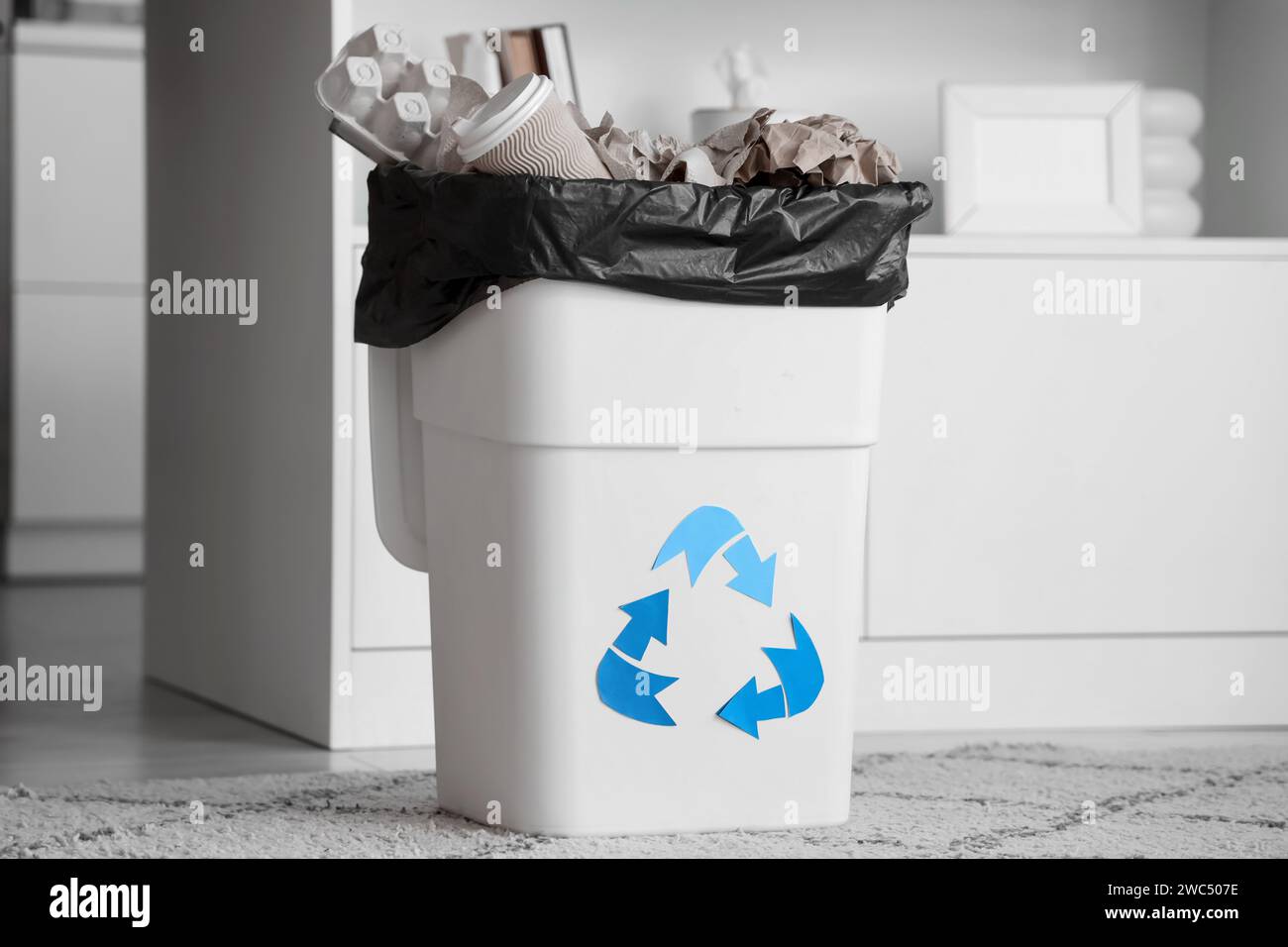Full trash bin with different garbage and recycle logo in kitchen ...