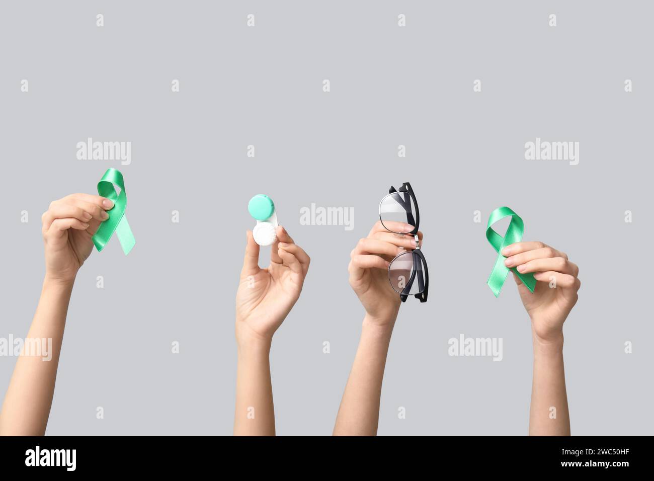 Female hands with container for contact lenses, green ribbons and ...