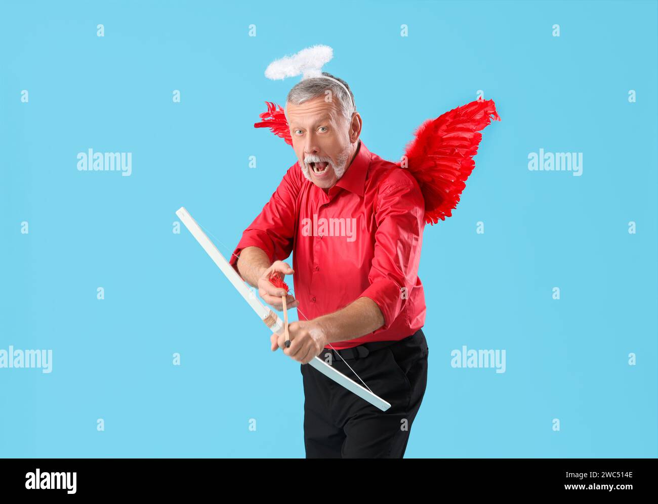 Shocked mature man dressed as Cupid with bow on blue background ...